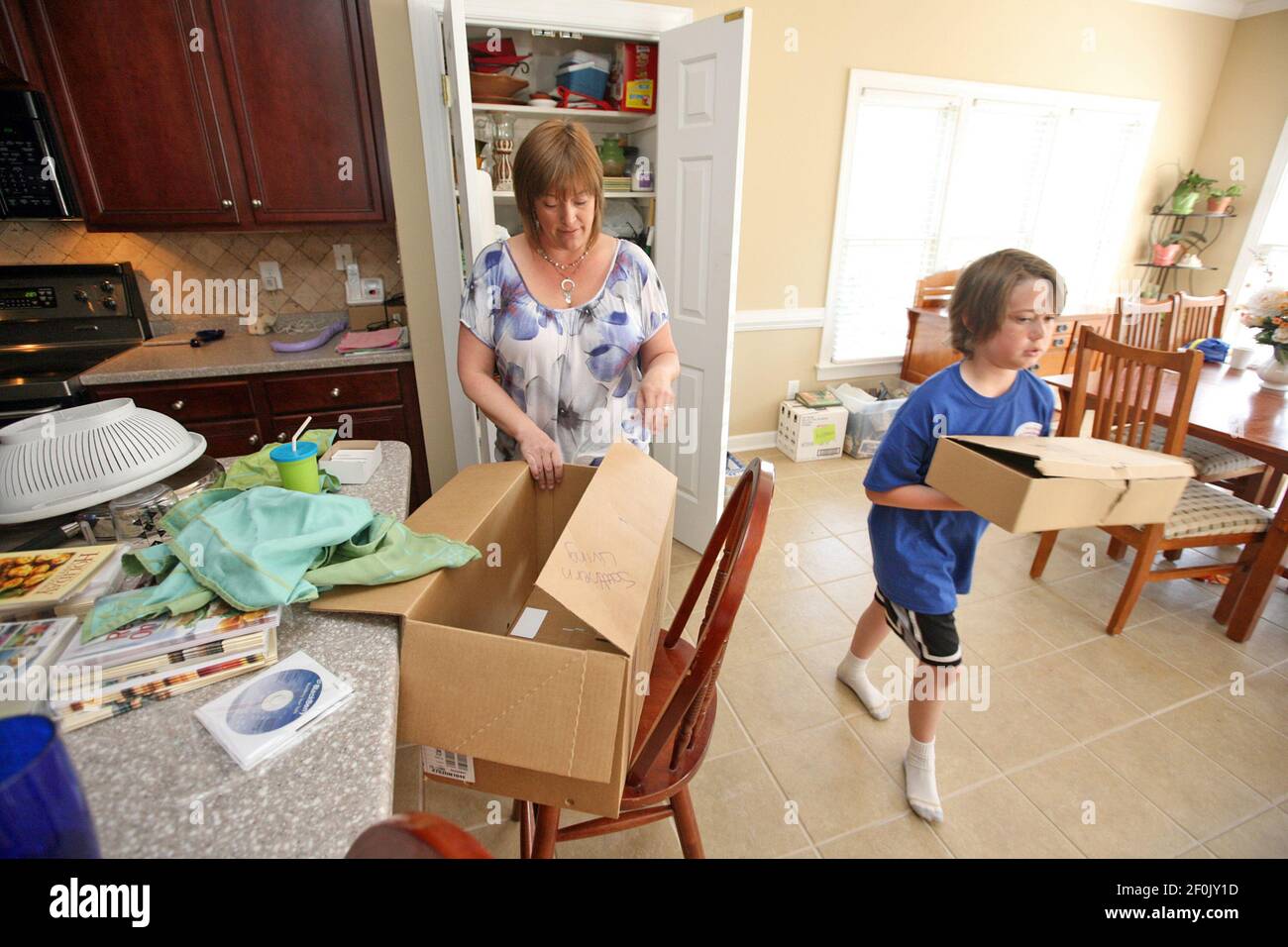 Lauri Moore, left, and her son, Mark Alan Moore, 9, unpack in their new ...