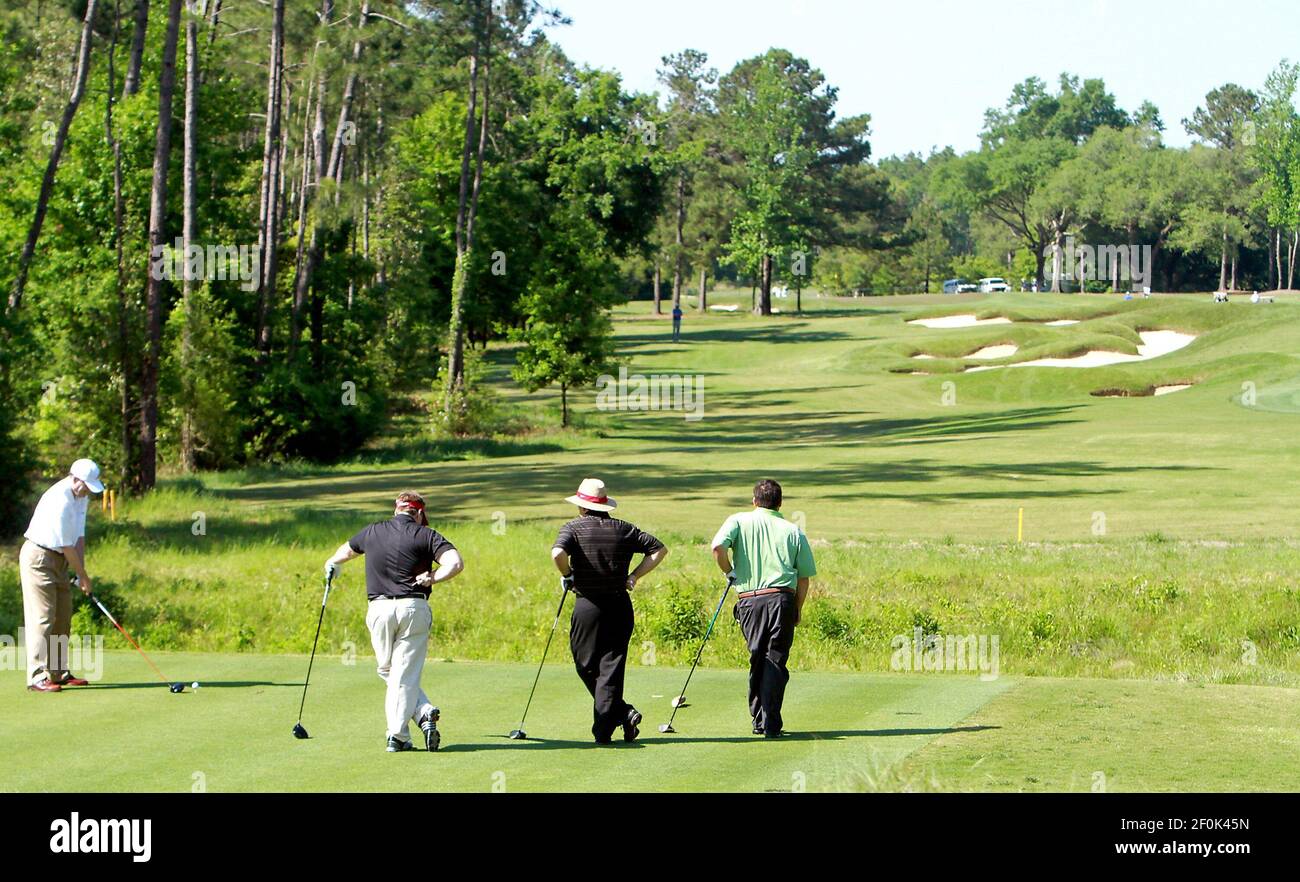 Alabama head football coach Nick Saban, center, waits to tee off with ...