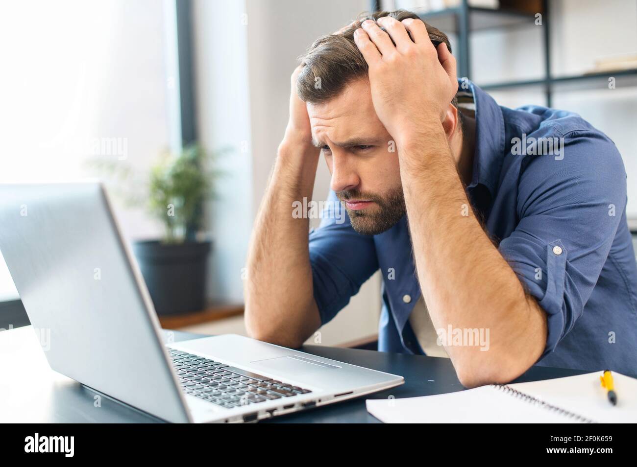Terrified young adult businessman terrified looking at computer screen ...