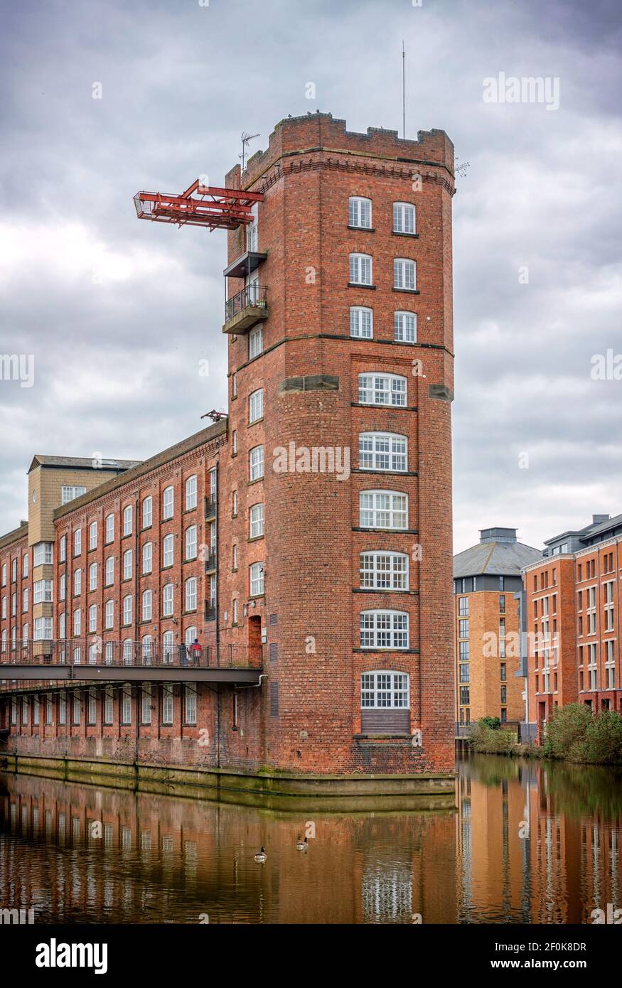 An old bridge spans a river between two buildings. The bridge is ...