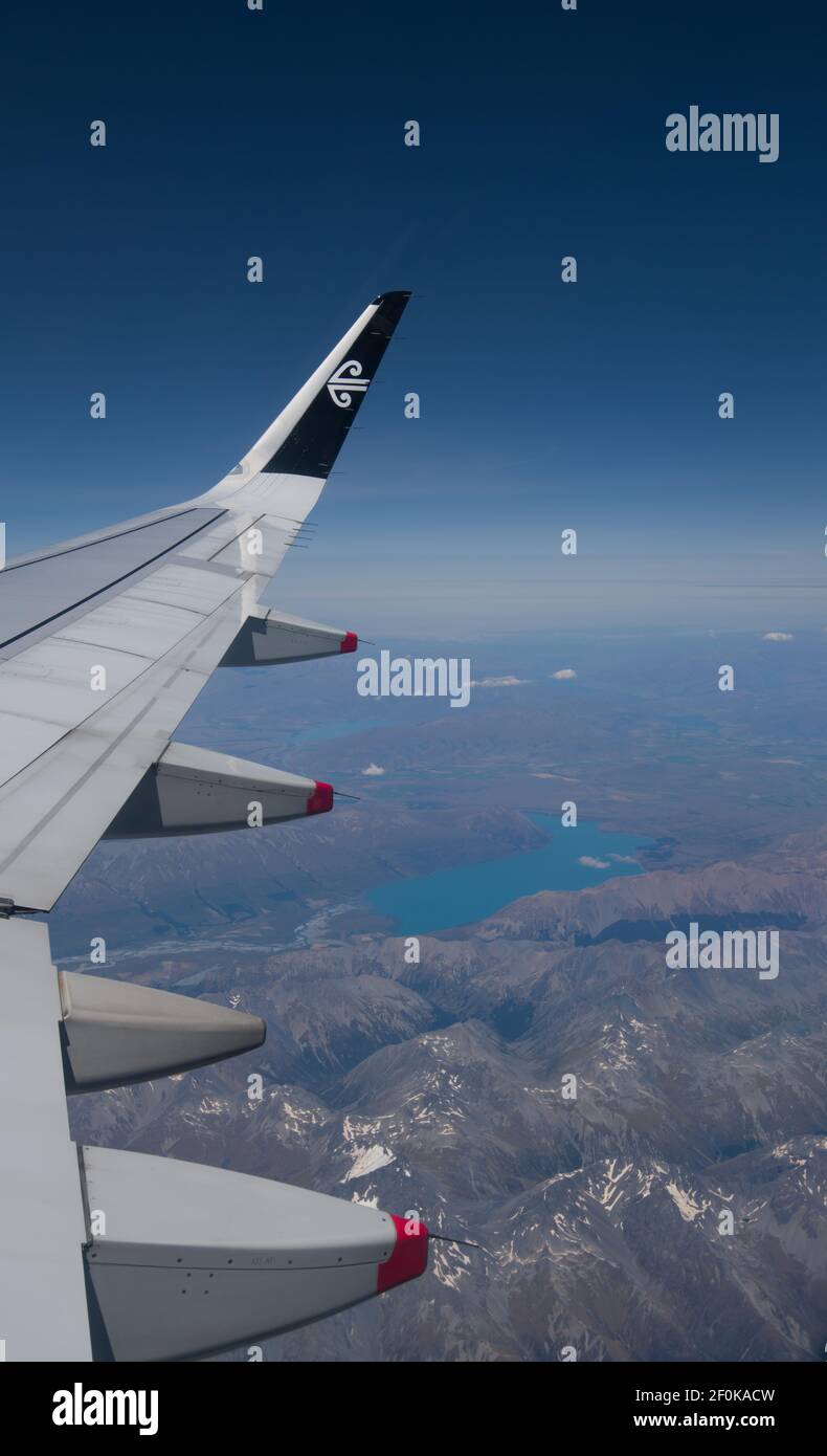 View of airplane wing out of plane window flying over New Zealand view ...