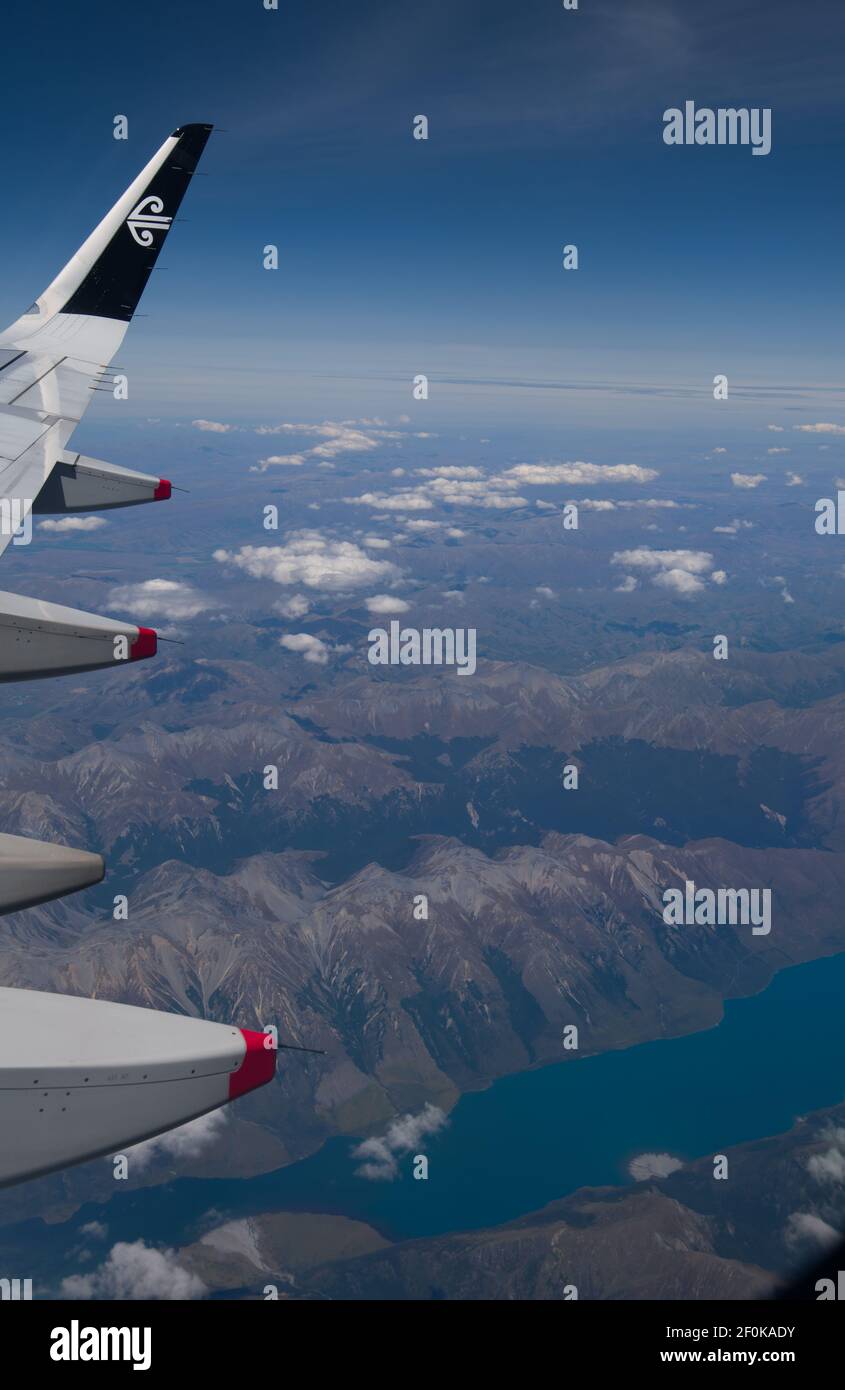 View of airplane wing out of plane window flying over New Zealand view ...