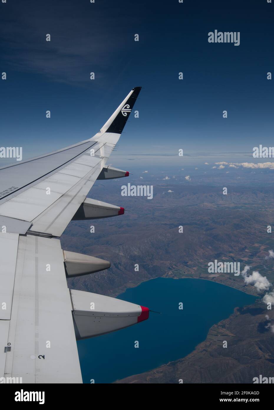 View of airplane wing out of plane window flying over New Zealand view ...