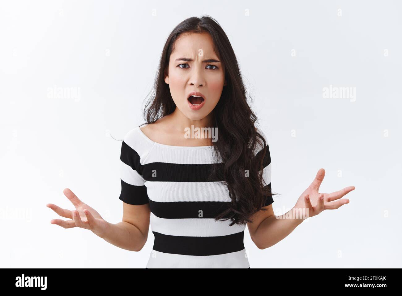 Outraged, pissed angry asian woman in striped t-shirt, have huge ...