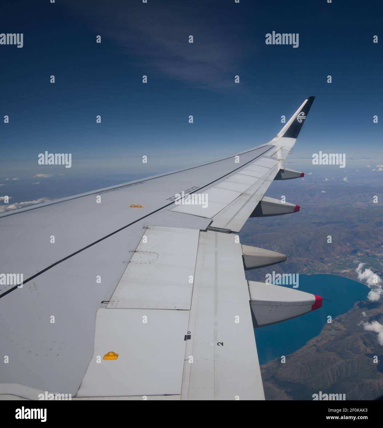 View of airplane wing out of plane window flying over New Zealand view ...