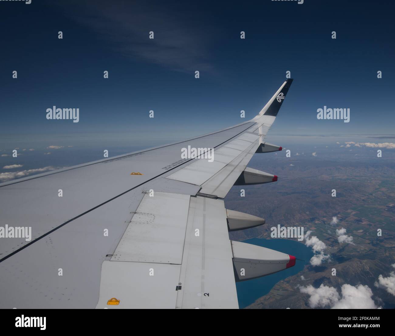 View of airplane wing out of plane window flying over New Zealand view ...