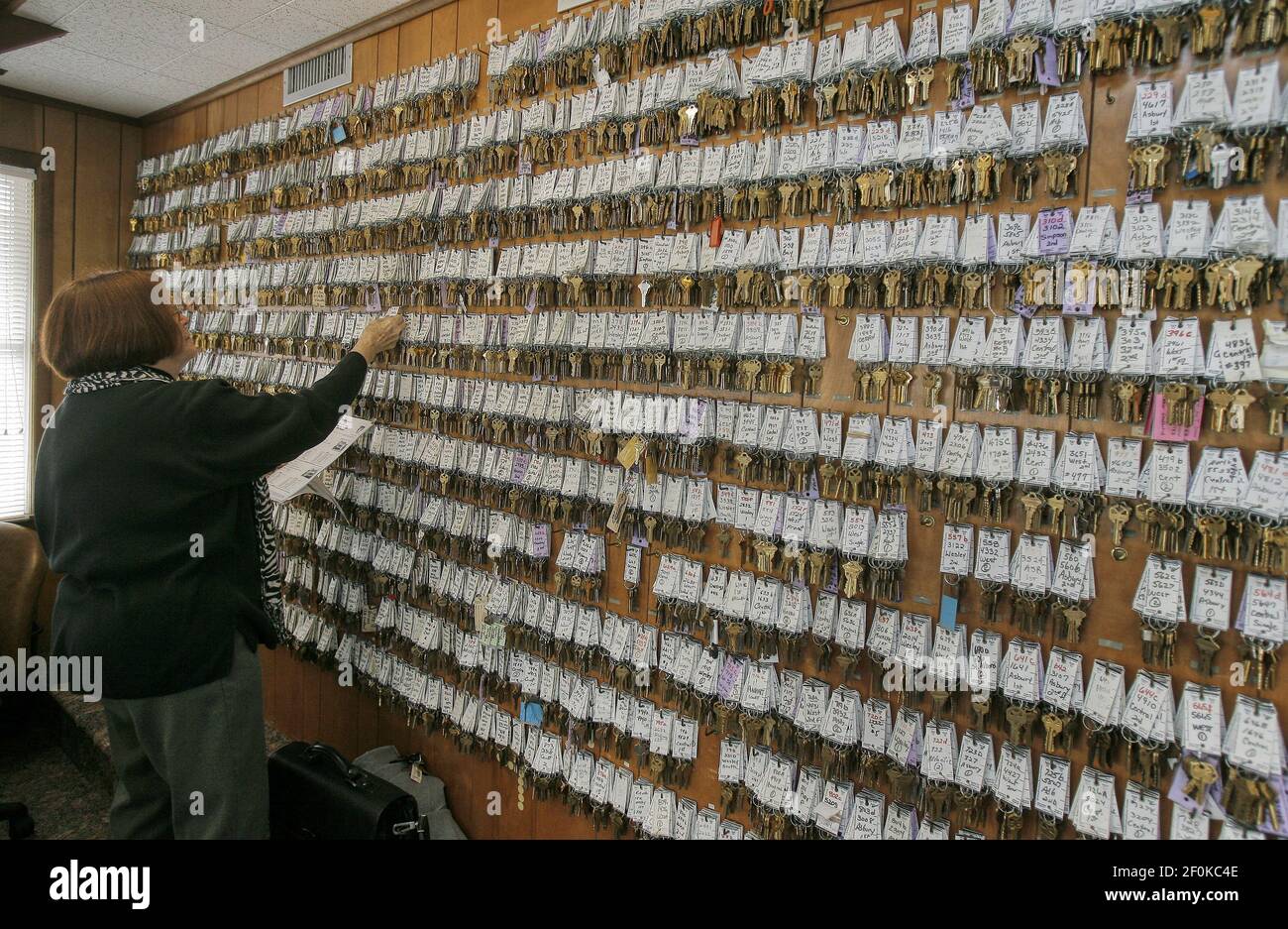 Rental agent Pat Moss picks up keys from a wall rack full of keys for ...