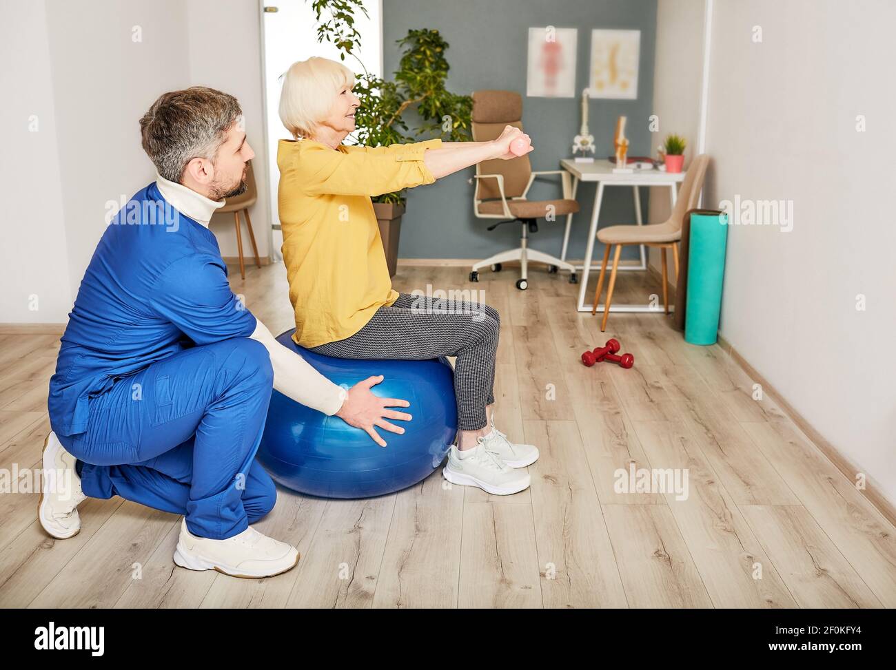 Senior woman doing treatment exercise at a rehab center with a male ...