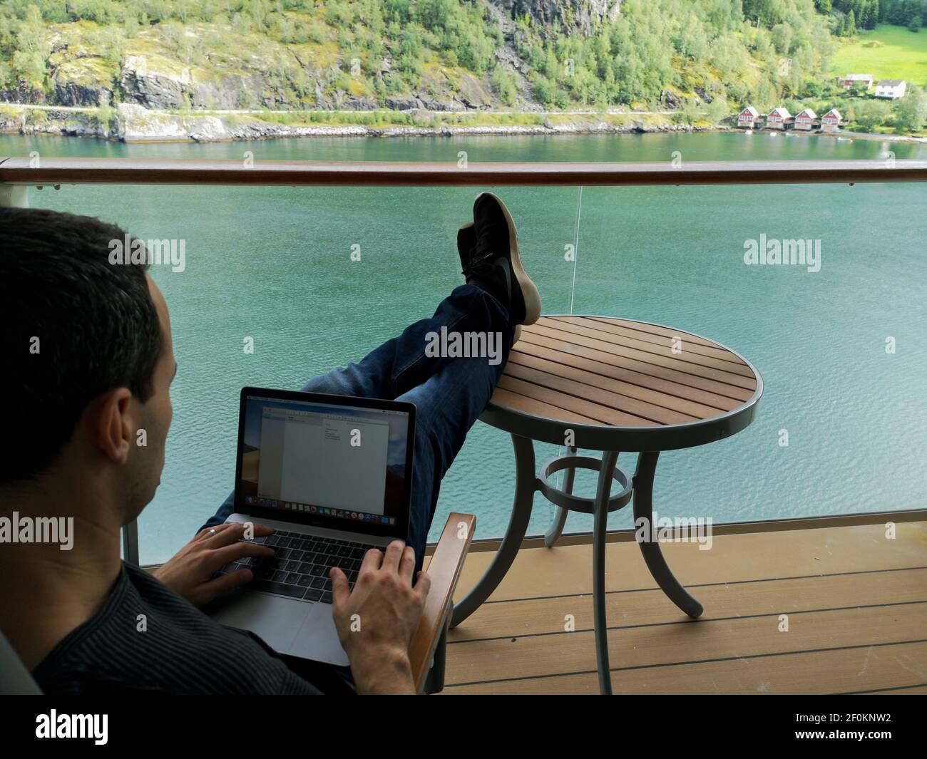 A cruise ship guest uses his laptop on a balcony whilst the ship is ...