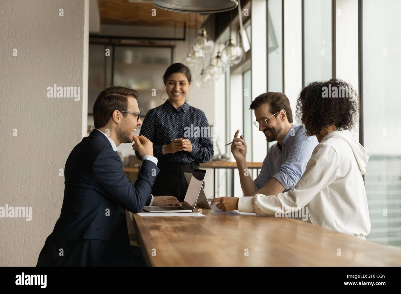 Happy diverse colleagues having fun at corporate meeting, laughing ...