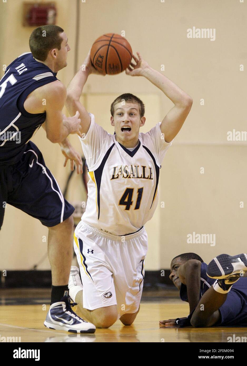La Salle's Steve Weingarten (41) passes the basketball from his knees ...