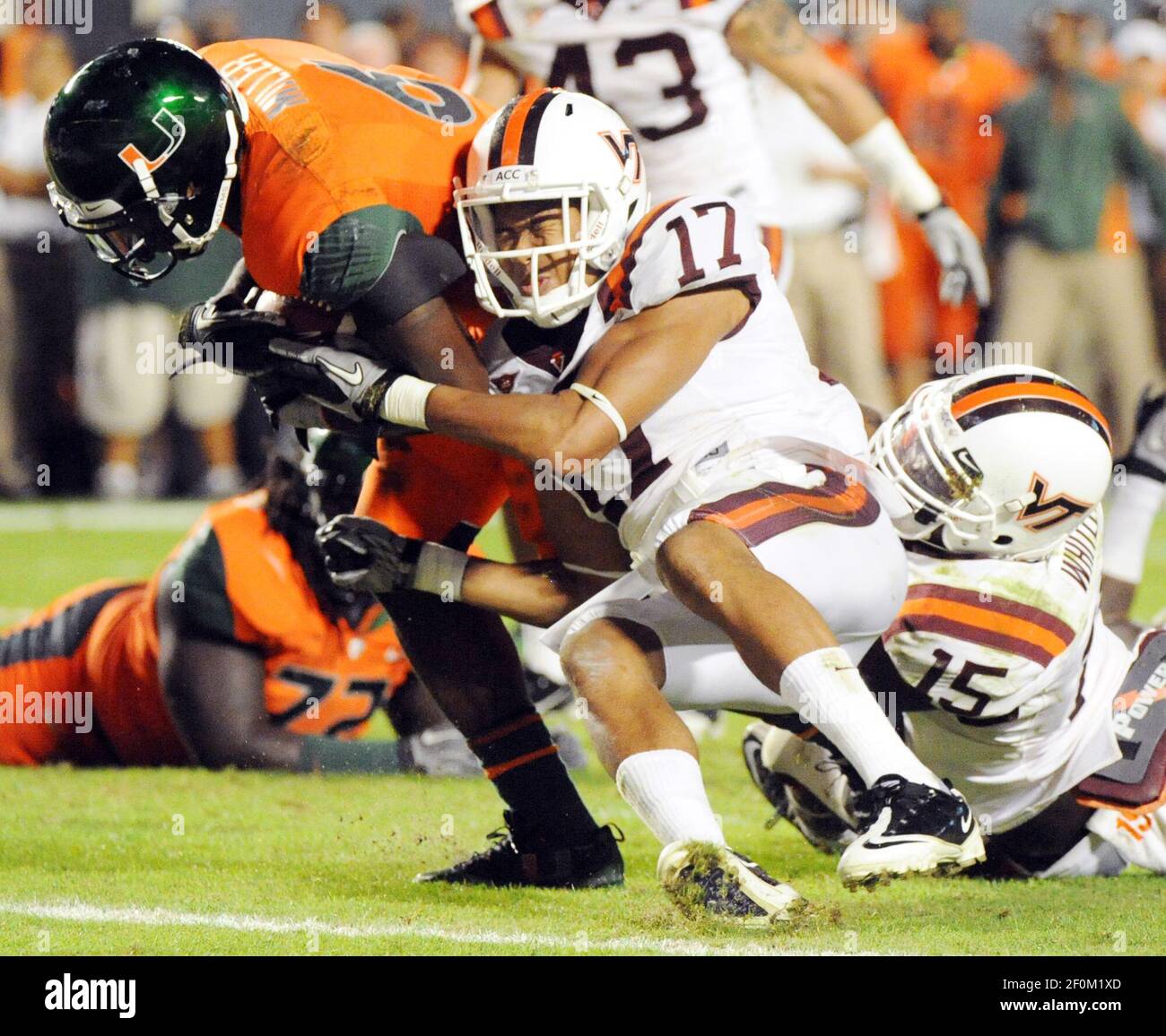 Lamar Miller of Miami runs over Kyle Fuller of Virginia Tech as he ...