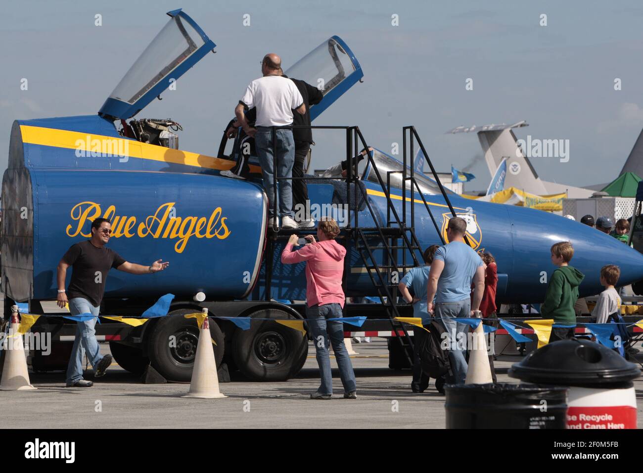Fans crowd around a Blue Angels cockpit model to have their photographs ...