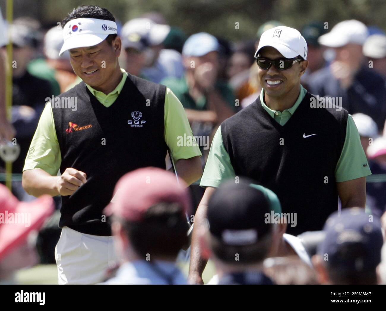 K.J. Choi and Tiger Woods (right) walk up to the tee box on the 8th ...