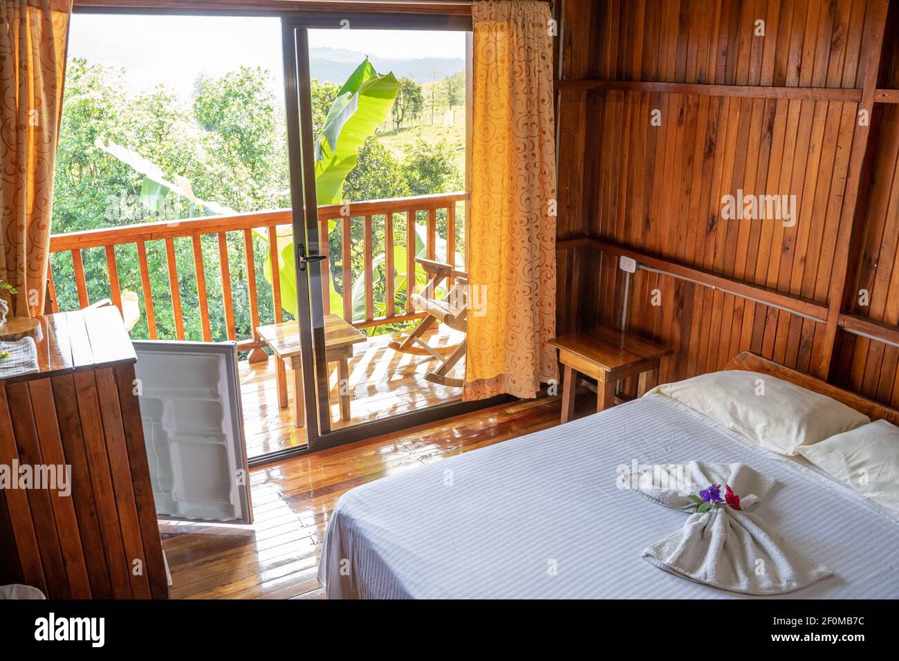 Rustic hotel room with a terrace with curtains and towels folded on the ...