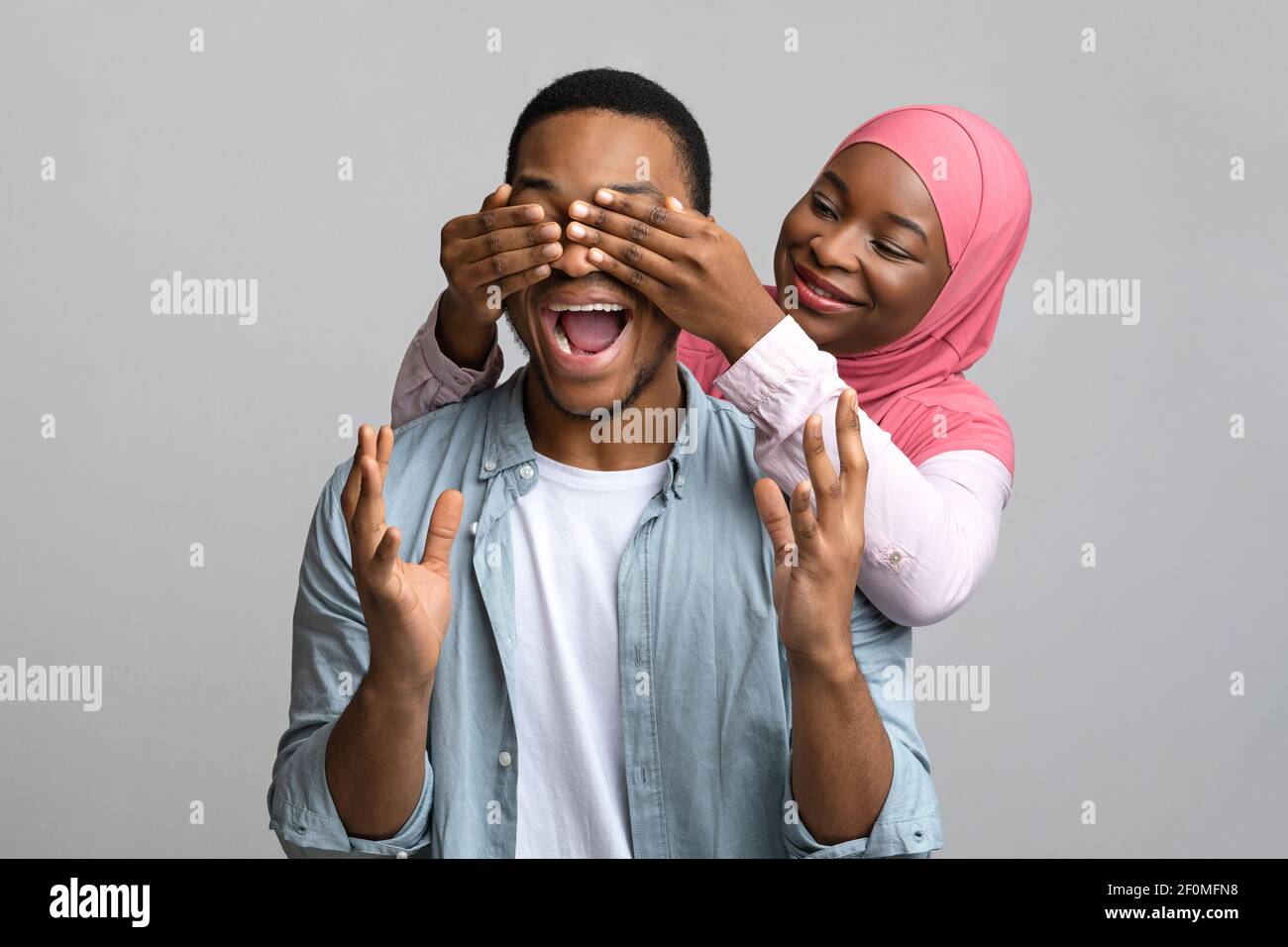 Pretty black lady in hijab covering her emotional boyfriend eyes Stock ...