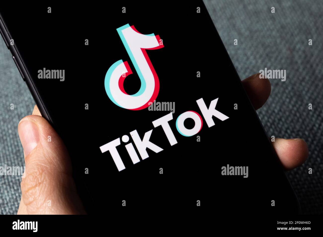 TikTok application icon on Apple iPhone 11 screen close-up. Hand ...