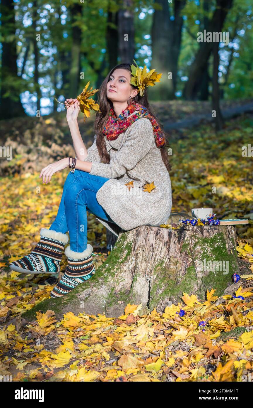 Happy girl sitting on stump Stock Photo - Alamy