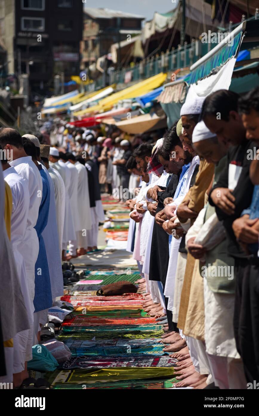 Kashmiri Muslims offer Prayers along a road outside Jamia masjid during ...