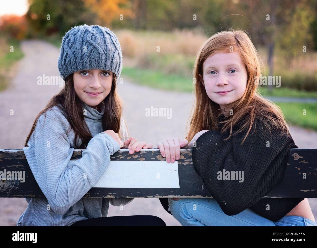 Two young tween girls in sweaters outdoors on country road Stock Photo ...