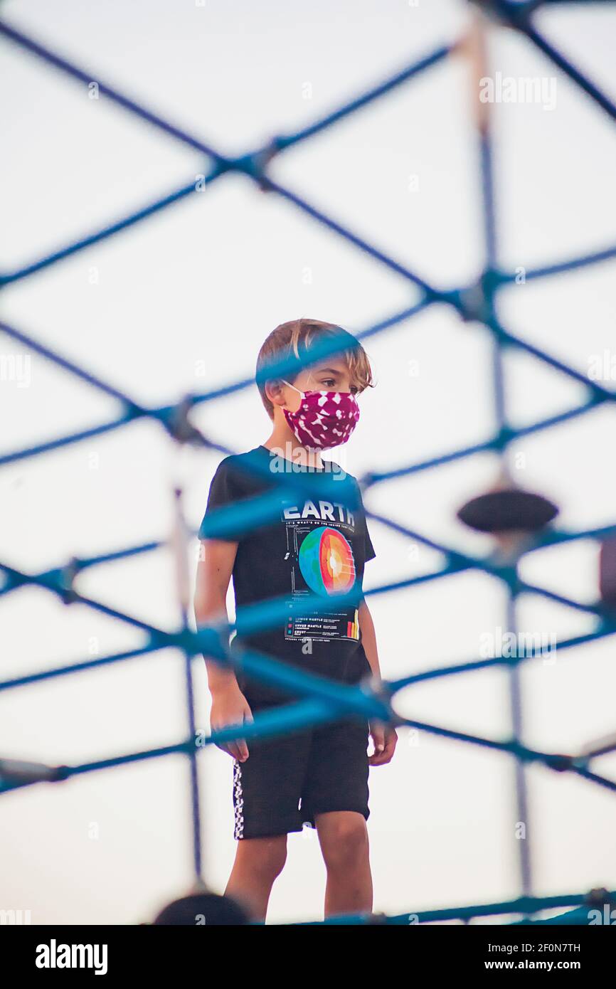 Boy wearing a mask playing alone at a playground Stock Photo - Alamy