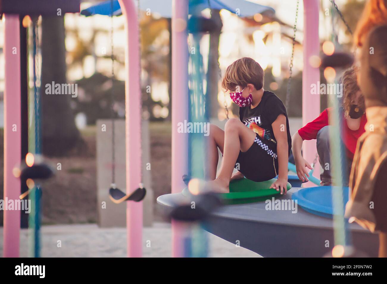 Boy wearing a mask playing alone at a playground Stock Photo - Alamy