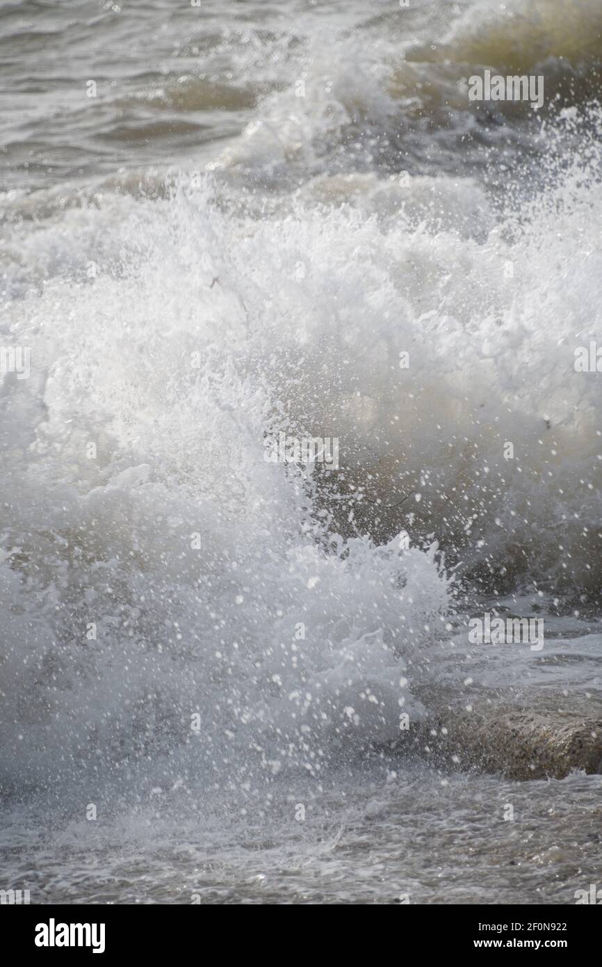 Waves from the English Channel breaking against a rock on a beach in ...