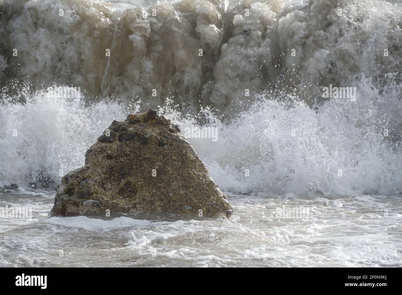 Waves from the English Channel breaking against a rock on a beach in ...