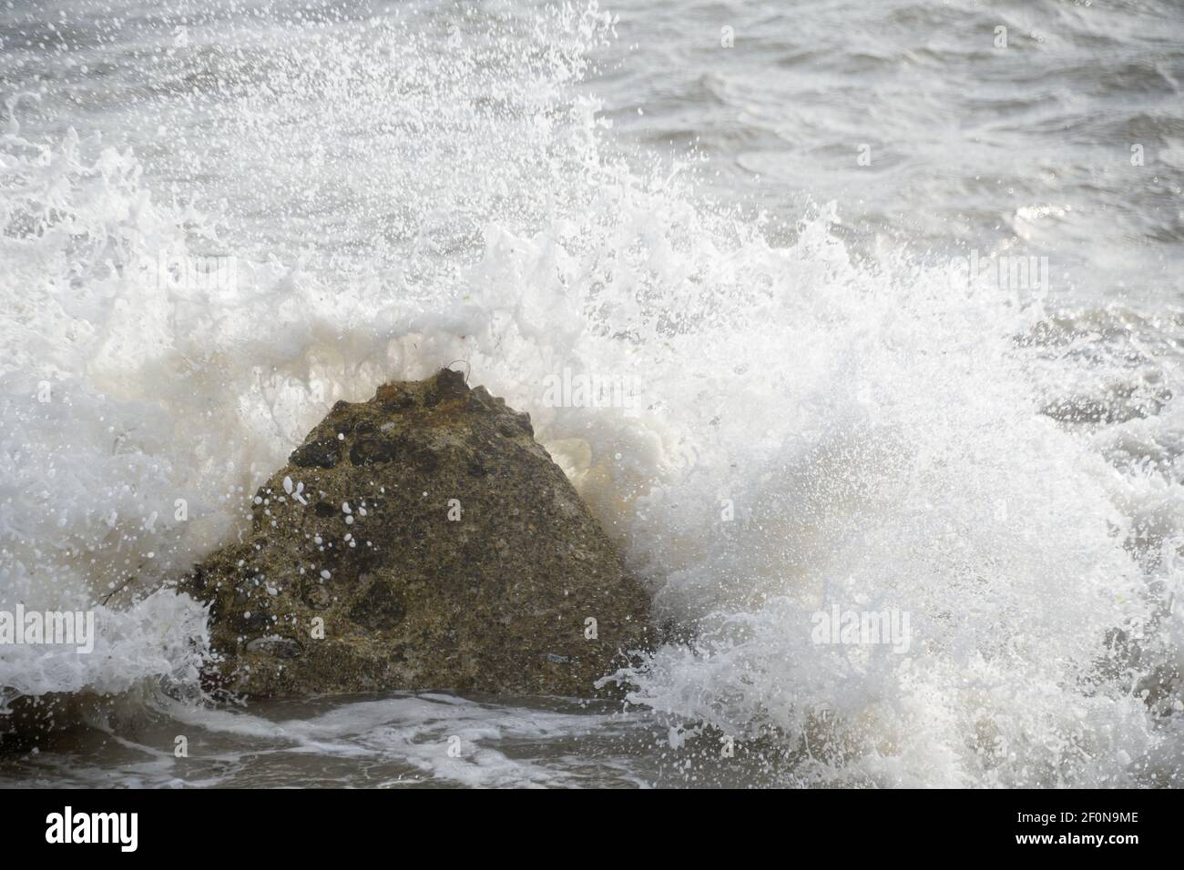 Waves from the English Channel breaking against a rock on a beach in ...