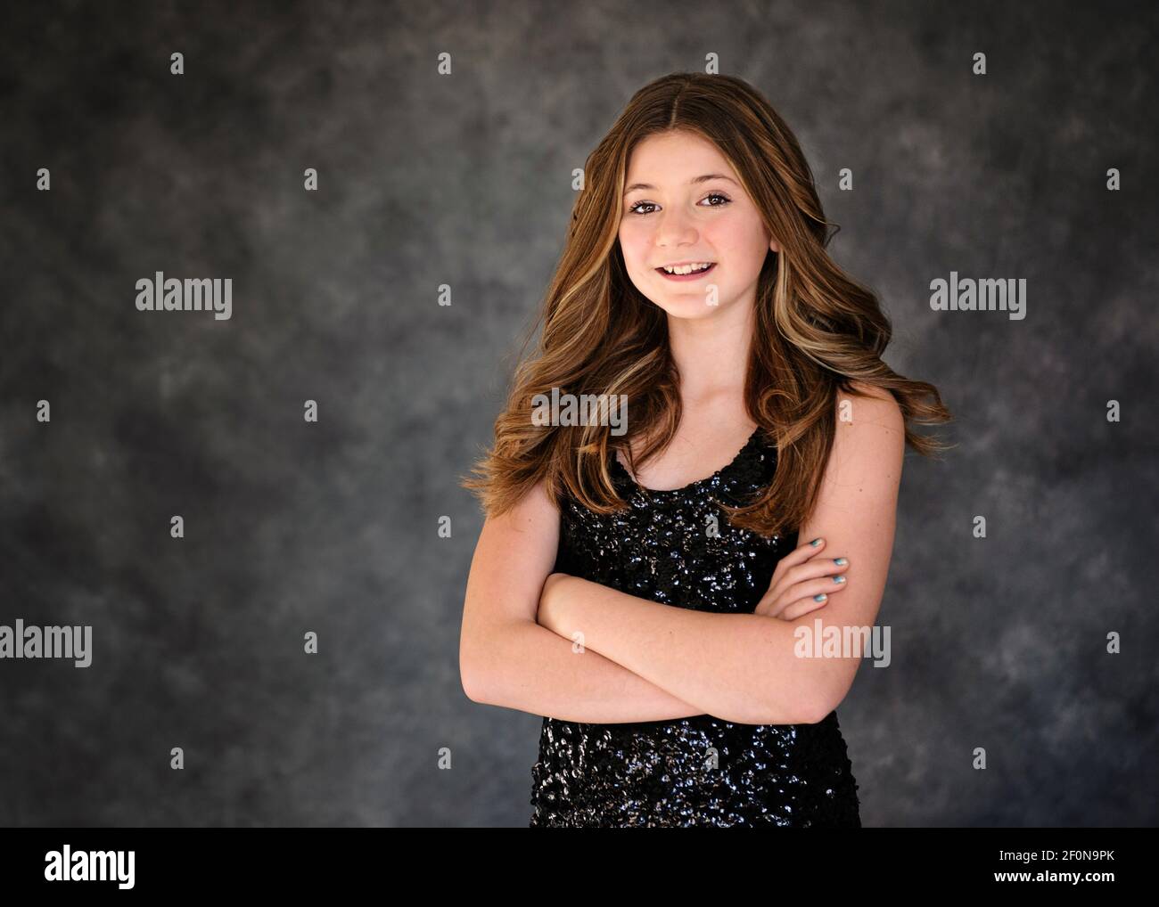 Beautiful and confident tween girl in black sparkly dress Stock Photo ...