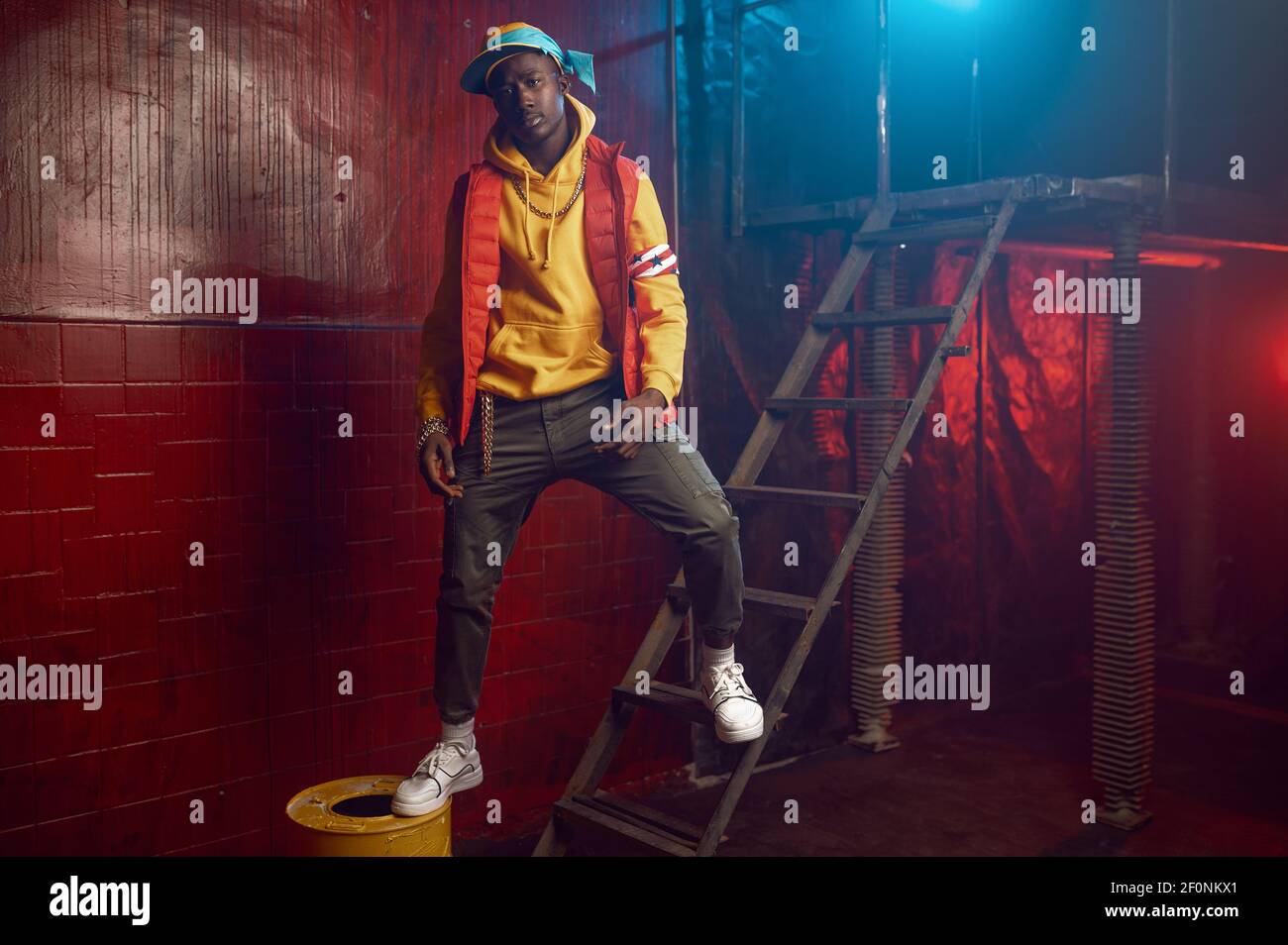 Stylish rapper poses on stairs in grunge studio Stock Photo - Alamy