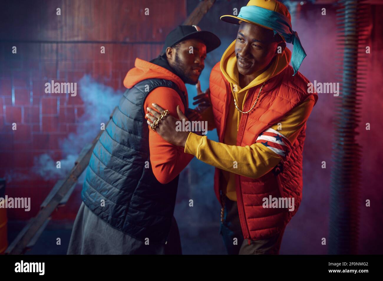 Two stylish rappers with gold jewelry in studio Stock Photo - Alamy