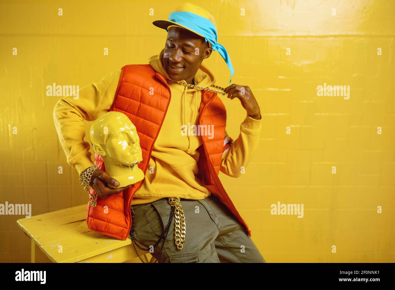 Stylish rapper poses in studio with yellow tones Stock Photo - Alamy