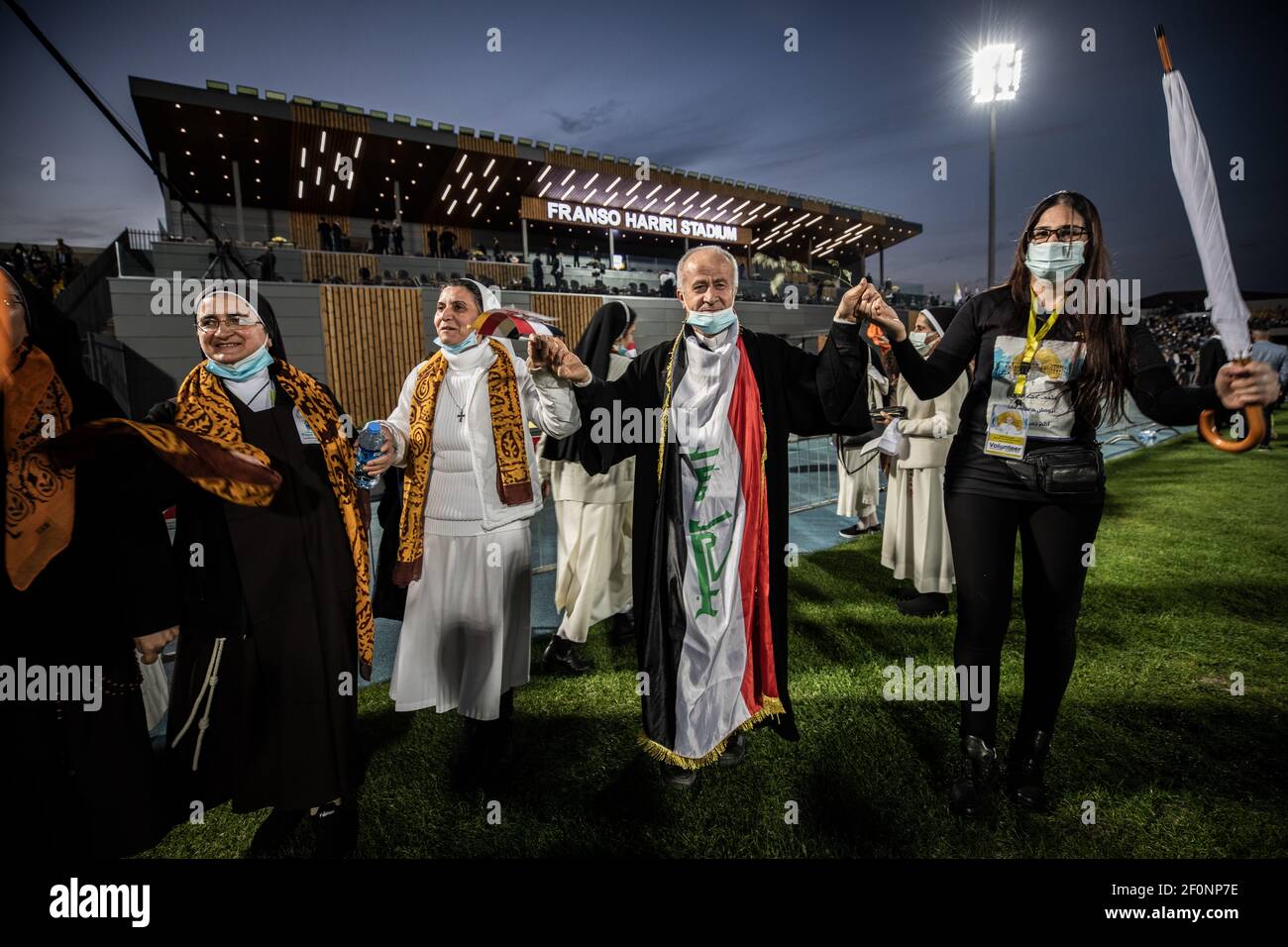 Erbil, Iraq. 07th Mar, 2021. Nuns and a man draped in the Iraqi flag ...