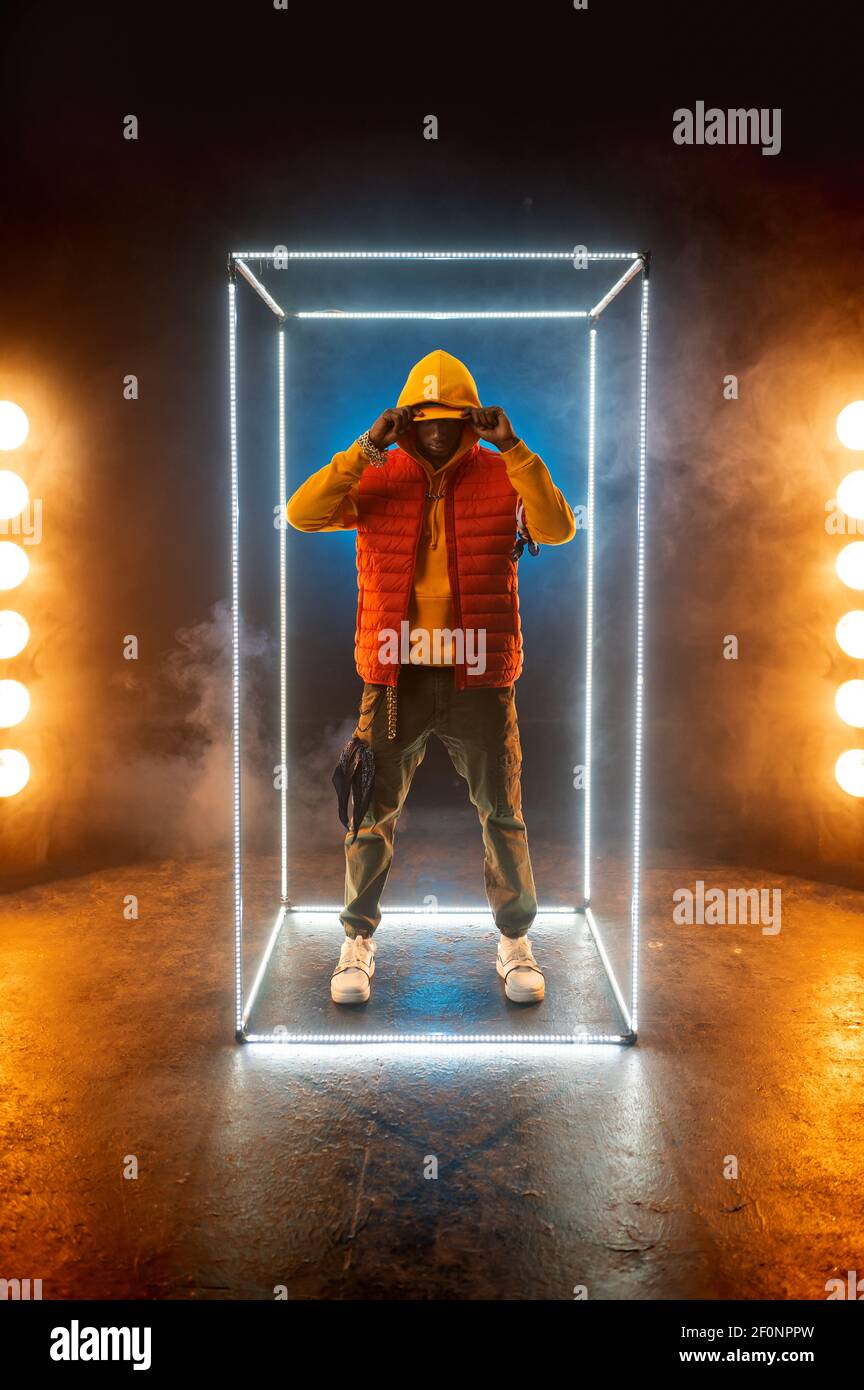 Stylish rapper poses in illuminated cube Stock Photo - Alamy