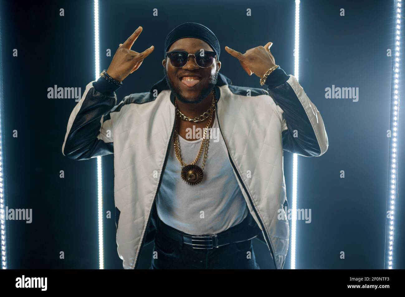 Smiling rapper on the stage with illuminated cube Stock Photo - Alamy