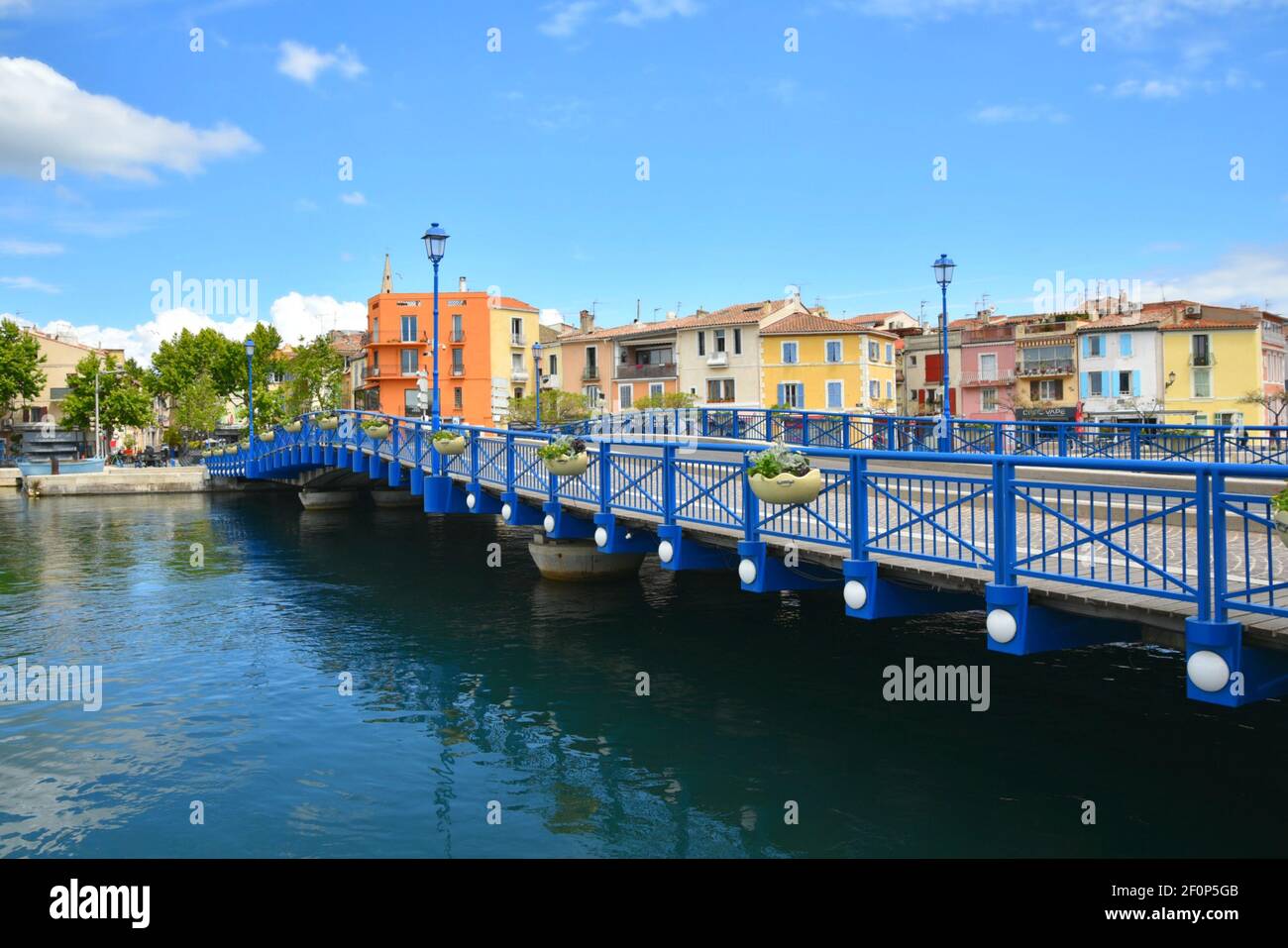Colorful picturesque houses across the blue landmark town bridge over the Etang de Berre in ...