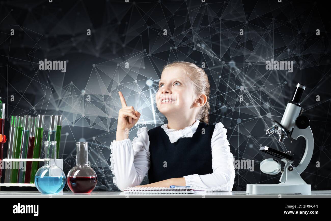 Little girl scientist sitting at desk Stock Photo - Alamy