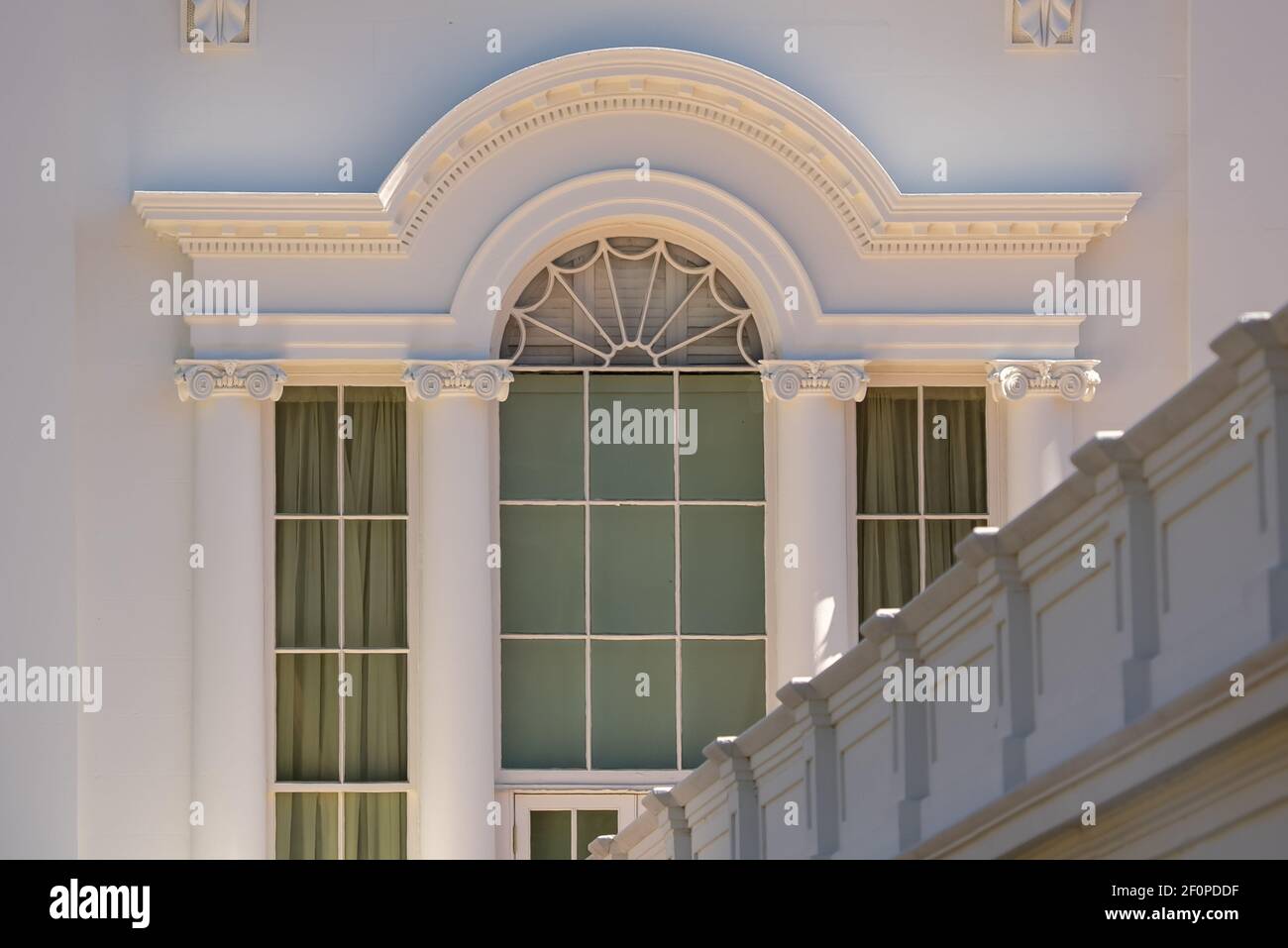 Stone swag and carvings are seen above the windows and columns of the ...