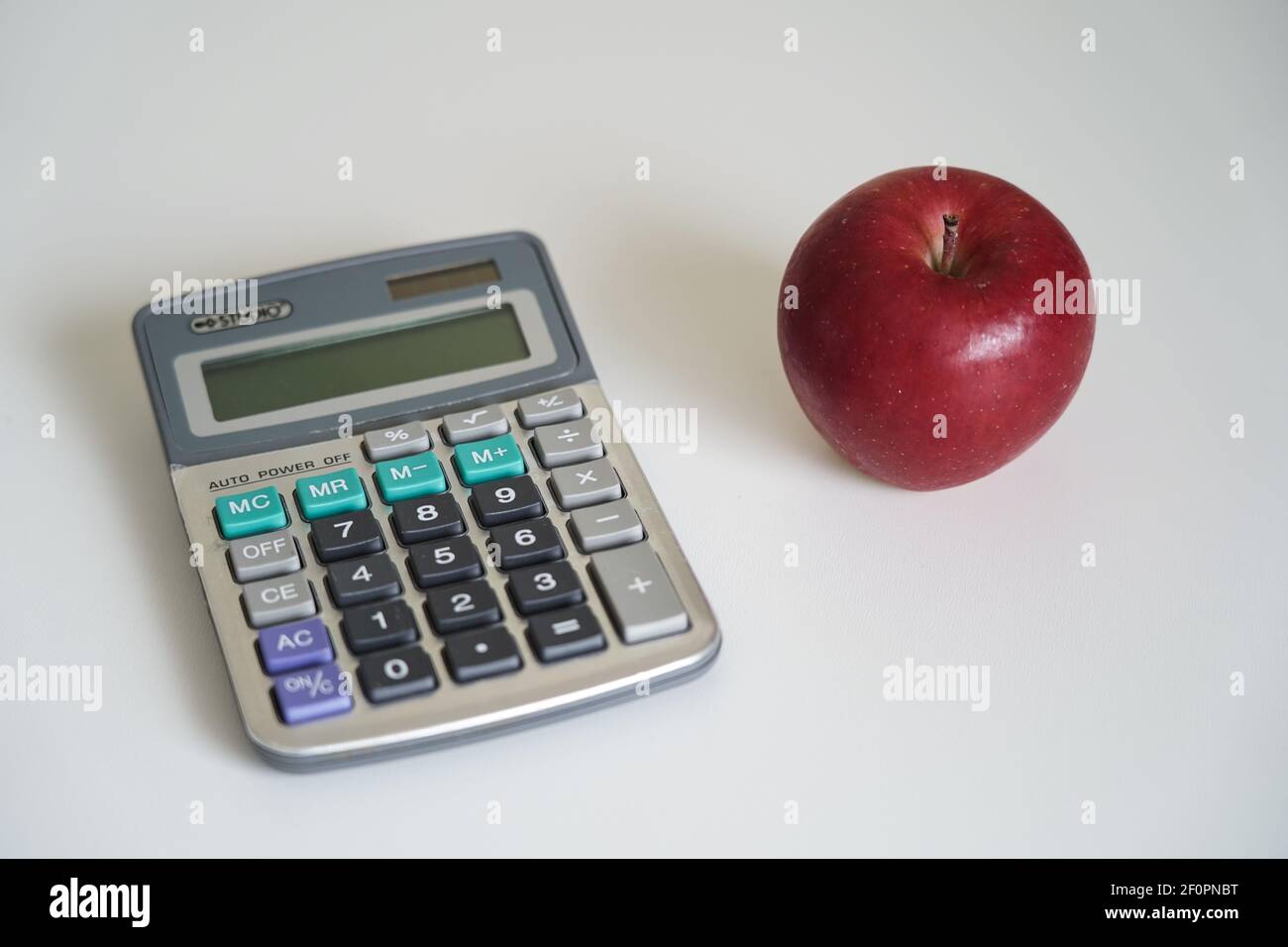 calculator and apple with a white background Stock Photo - Alamy