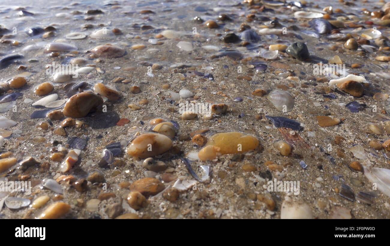 Low angle close view of moving sea water creating streams and corridors ...