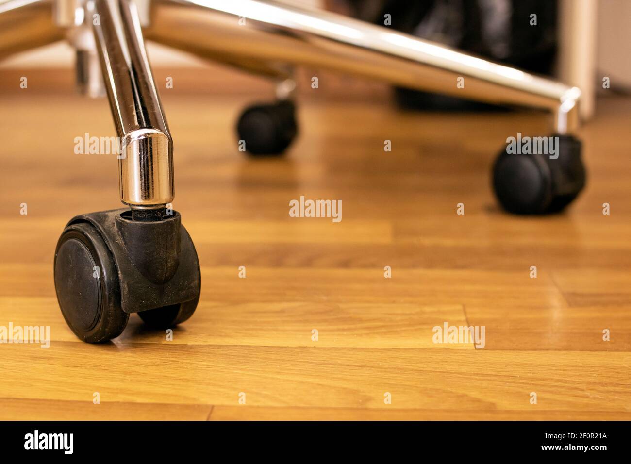 Office chair wheels on a wood floor close up Stock Photo - Alamy