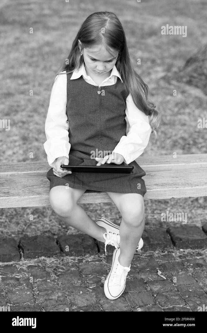 Little child in school uniform touch screen or touchscreen finger push ...