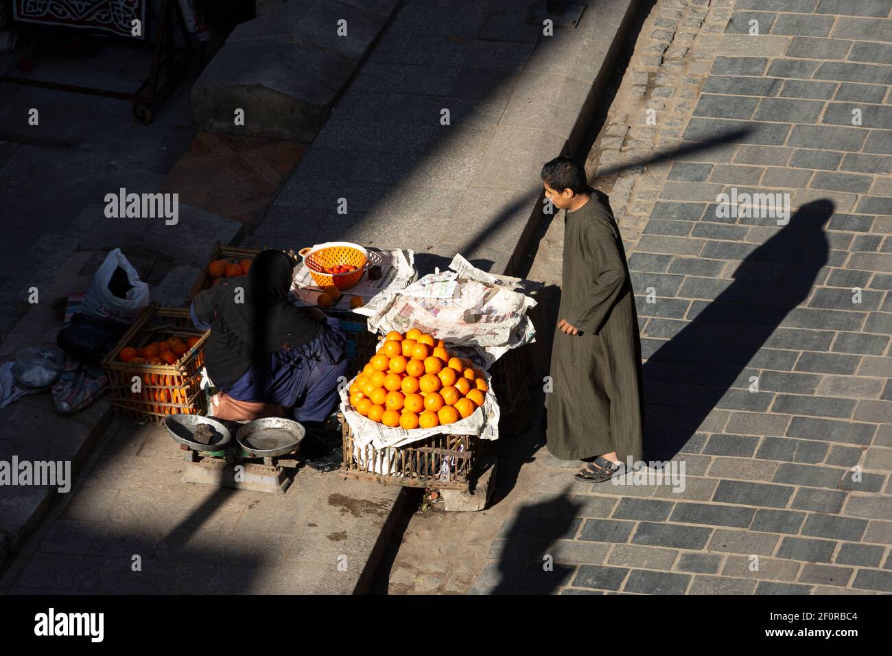 A local man buying oranges from a street vendor on the roadside near ...