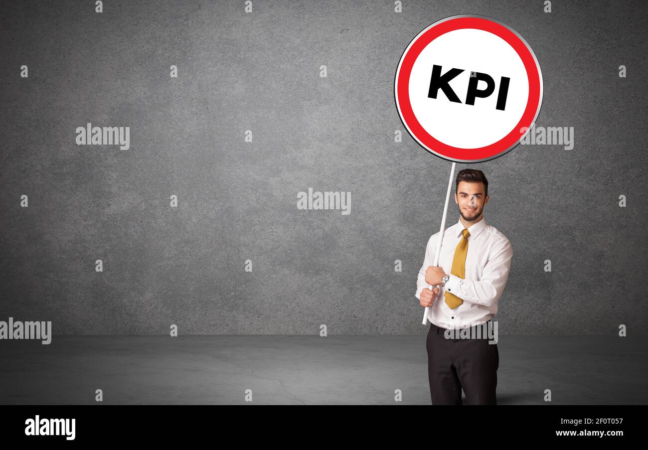 Young business person holdig traffic sign with KPI abbreviation ...
