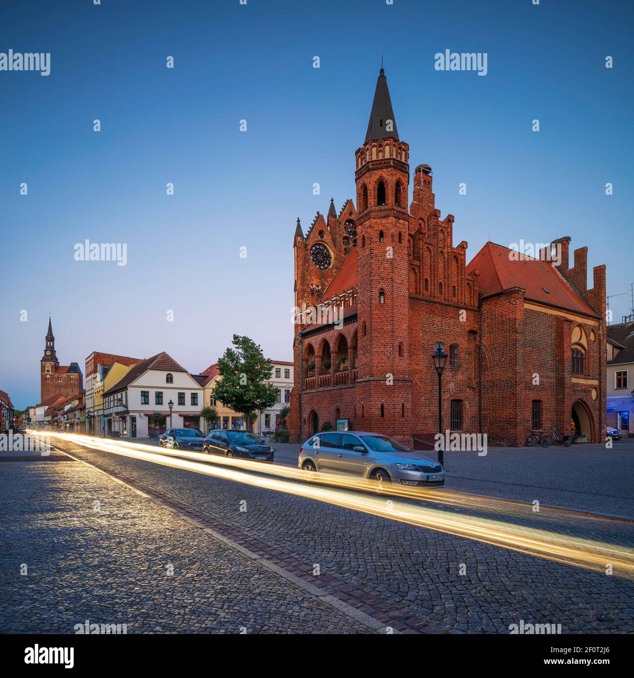 Town hall and church St. Stephan in the dusk, light trace of car on ...