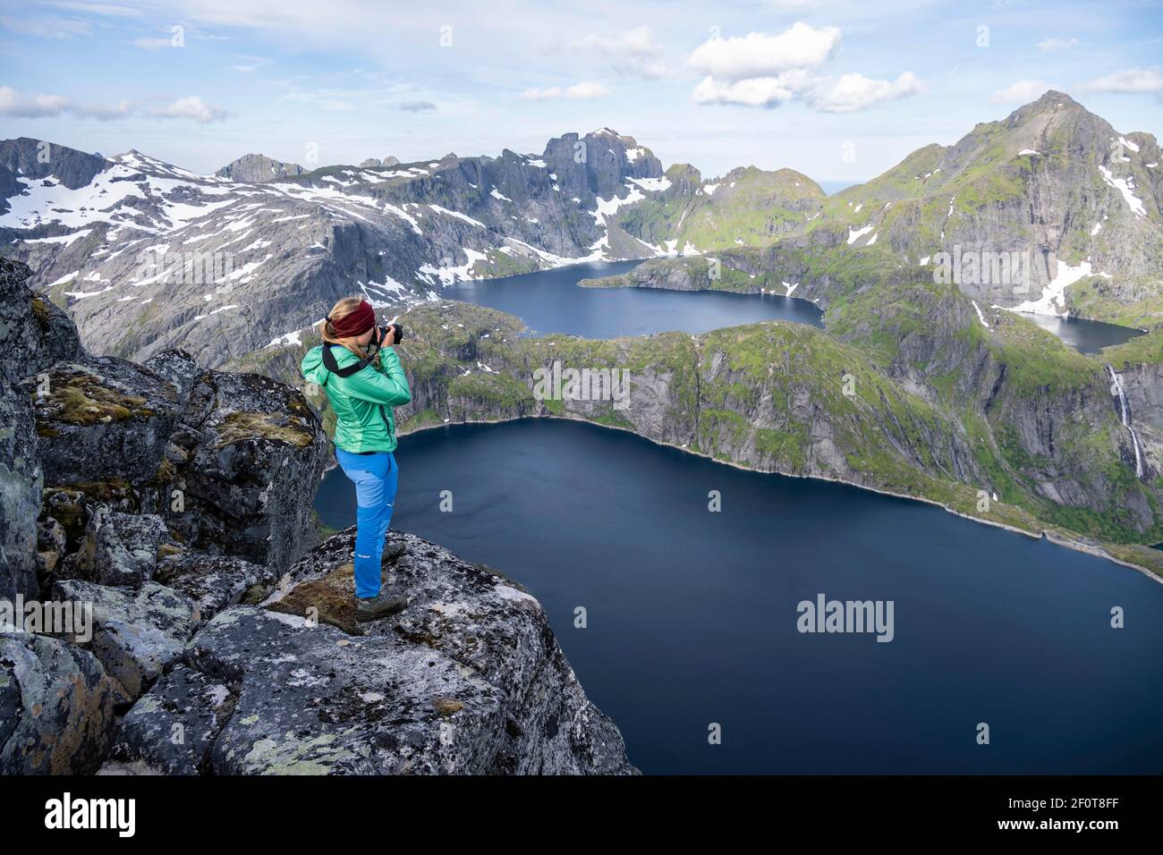 Young woman looking over mountain landscape with lake Tennesvatnet ...