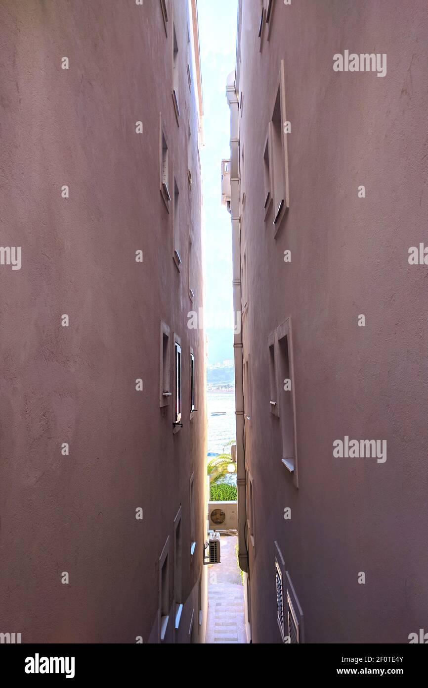 Between walls of houses. Narrow passage between walls, going to the ...