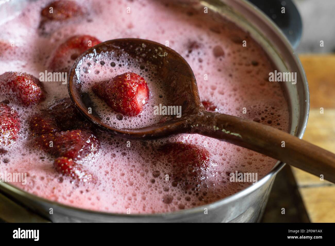 Cooking strawberry jam. Berries with sugar boiling in a pan forming a ...