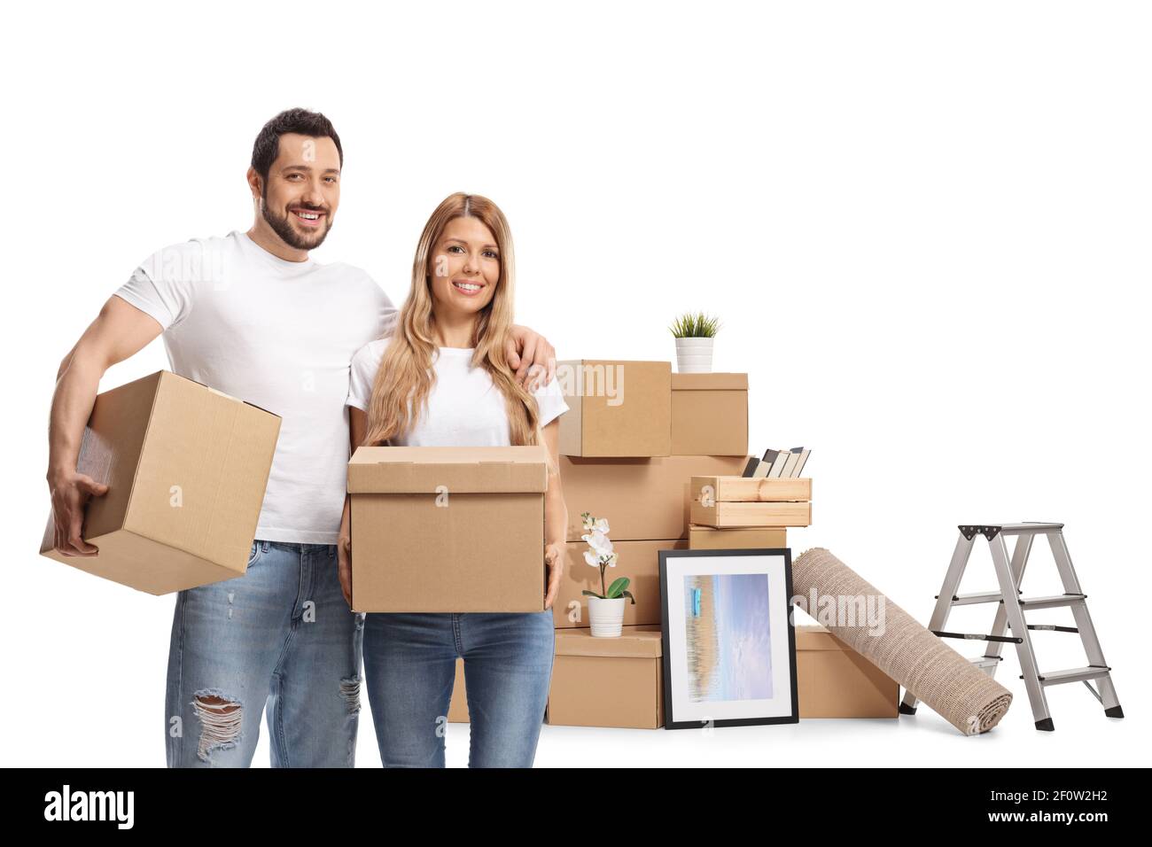 Young couple with a pile of cardboard boxes packing for home removal ...